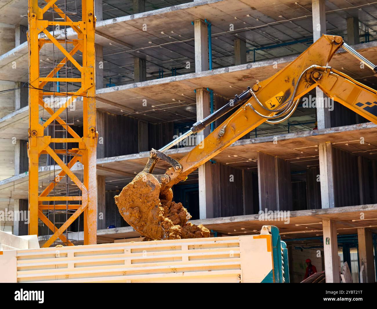 Excavator loads ground into a dump truck at a construction site Stock ...
