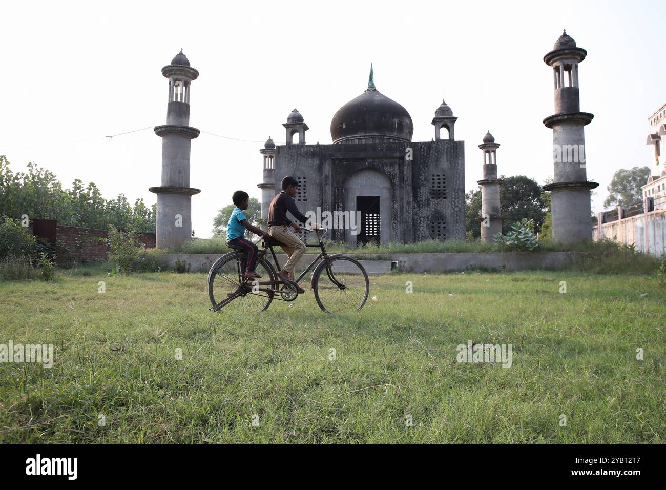 Kids ride a cycle at the compound of Mini Taj Mahal, officially known ...