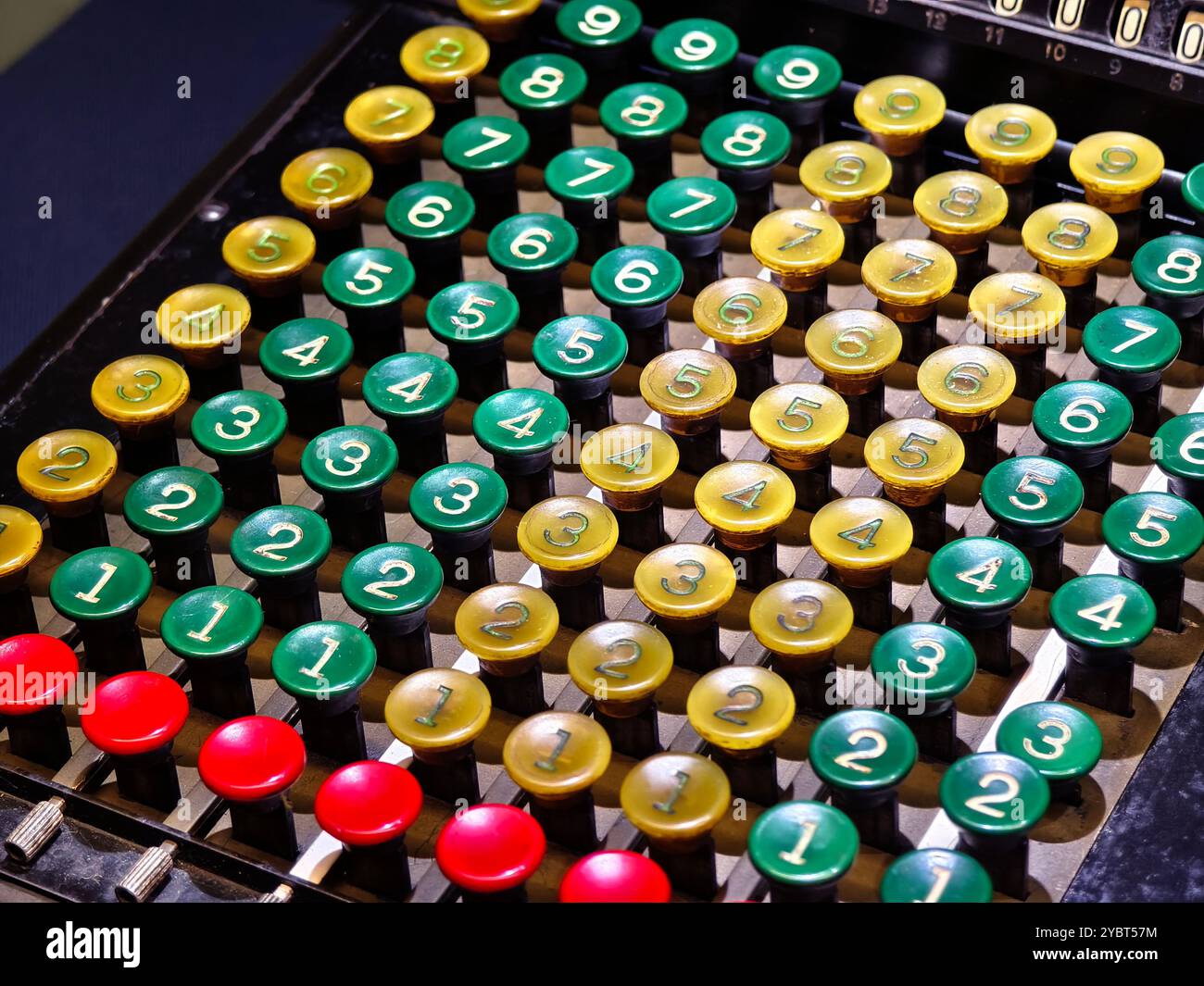 An old fashioned adding machine features a drawer located underneath it ...