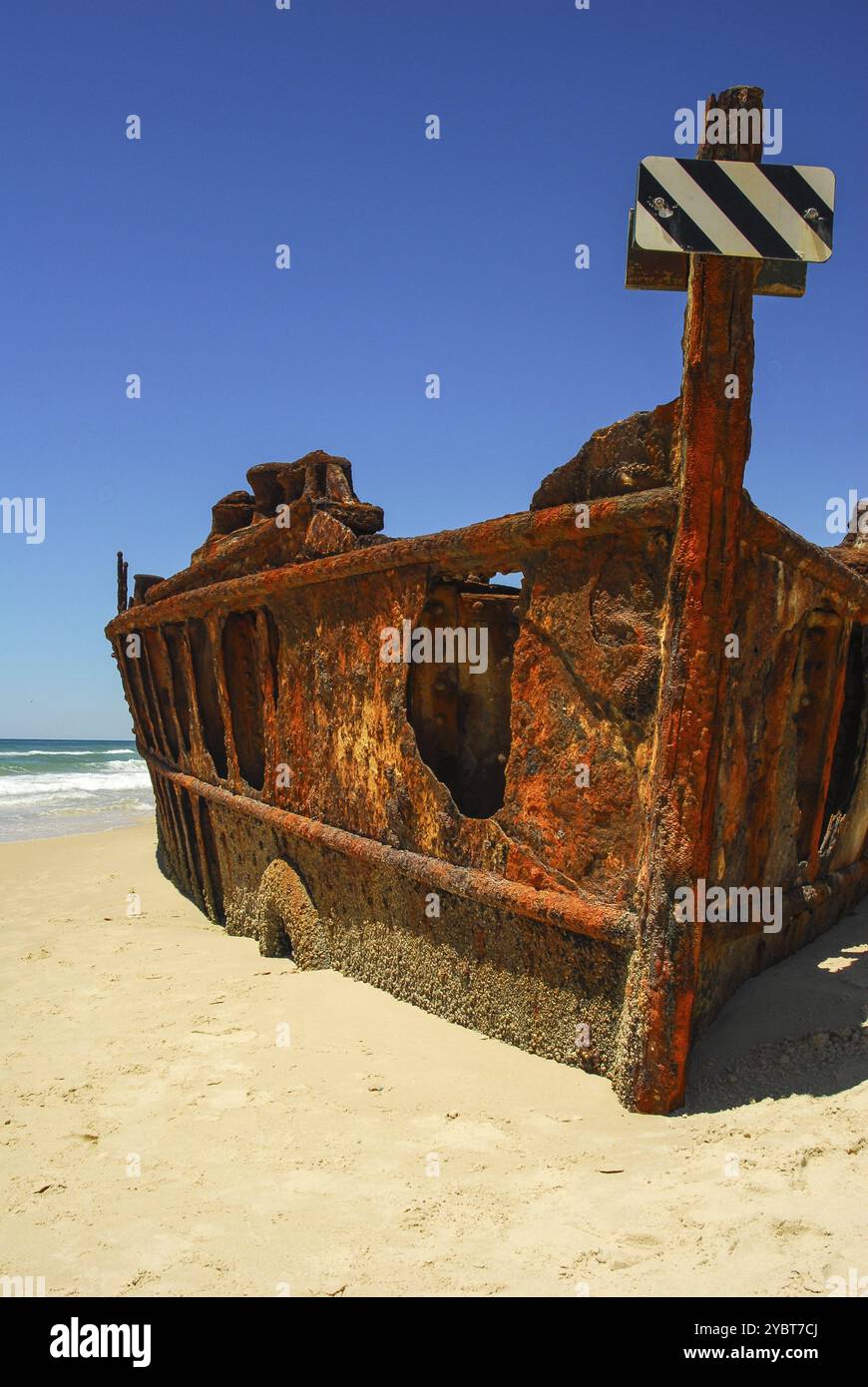 Rusty shipwreck on the beach under a clear blue sky, Fraser Island ...