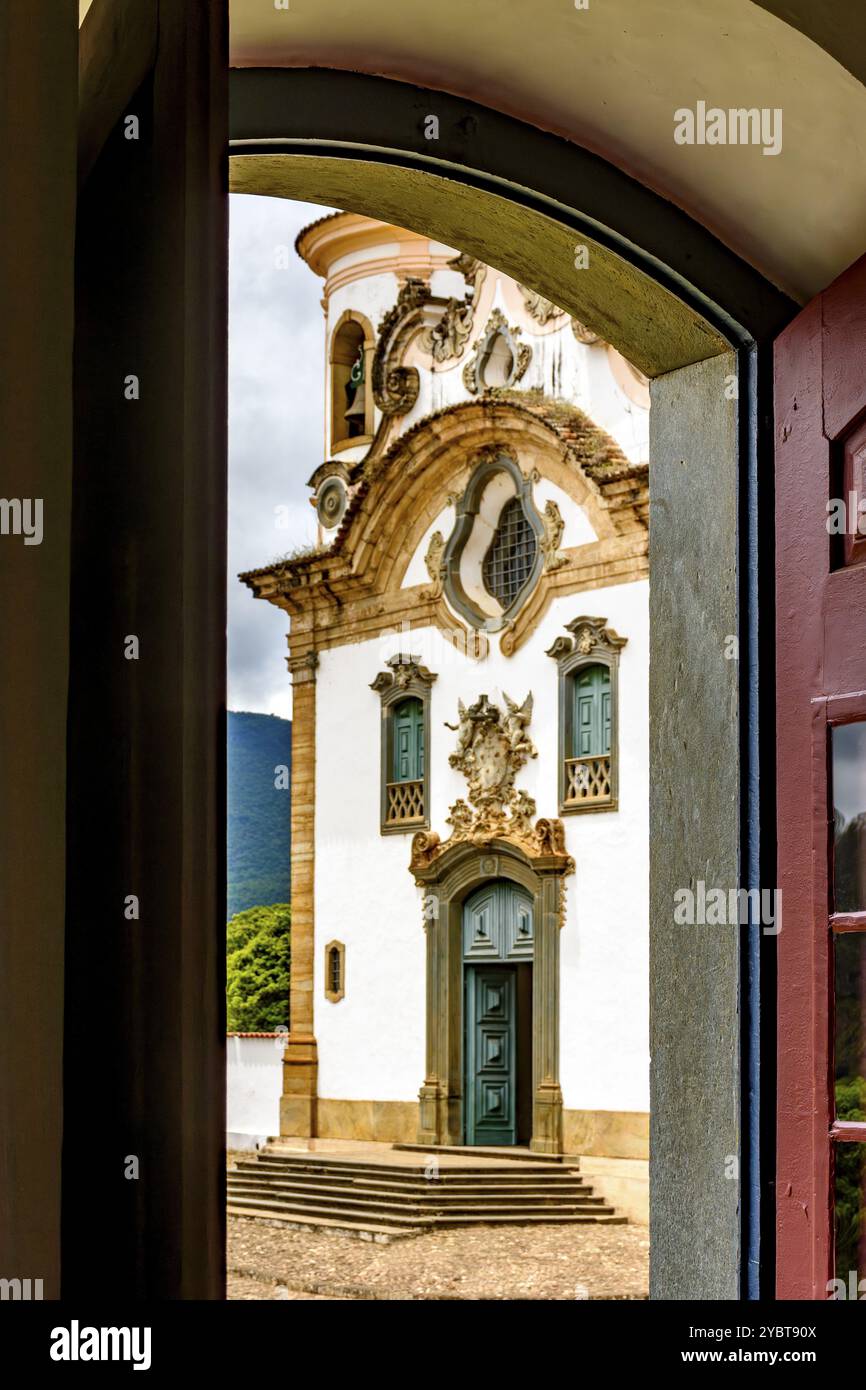 Baroque church facade seen through the window in the city of Mariana in ...