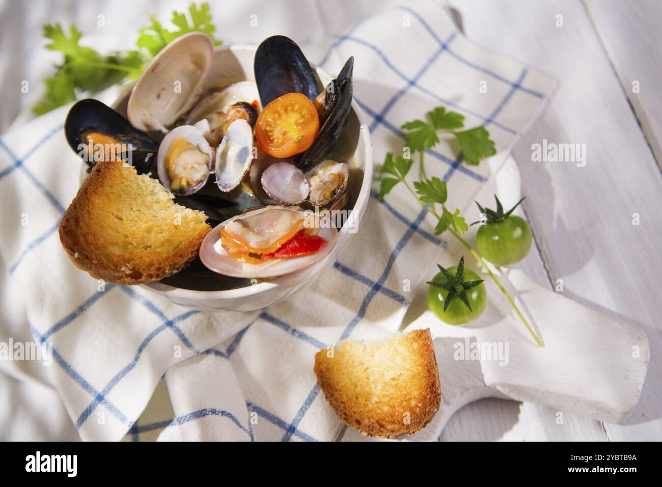 Presentation of a soup with seafood on white background Stock Photo - Alamy