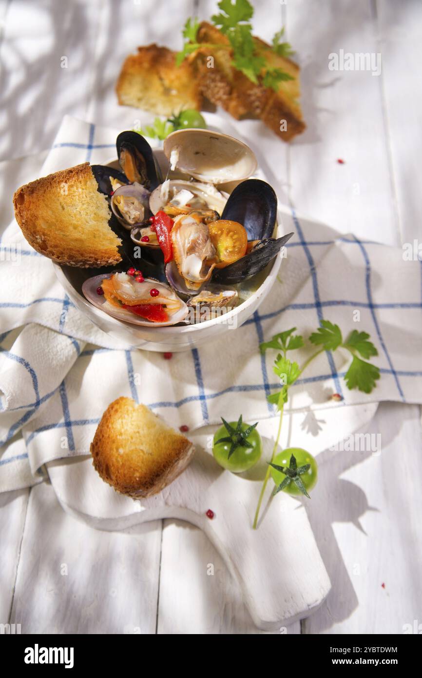 Presentation of a soup with seafood on white background Stock Photo - Alamy