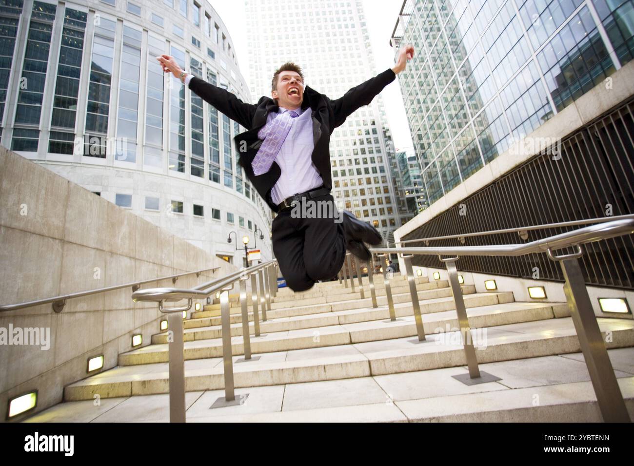 Happy caucasian businessman leaving the office jumping in the air ...