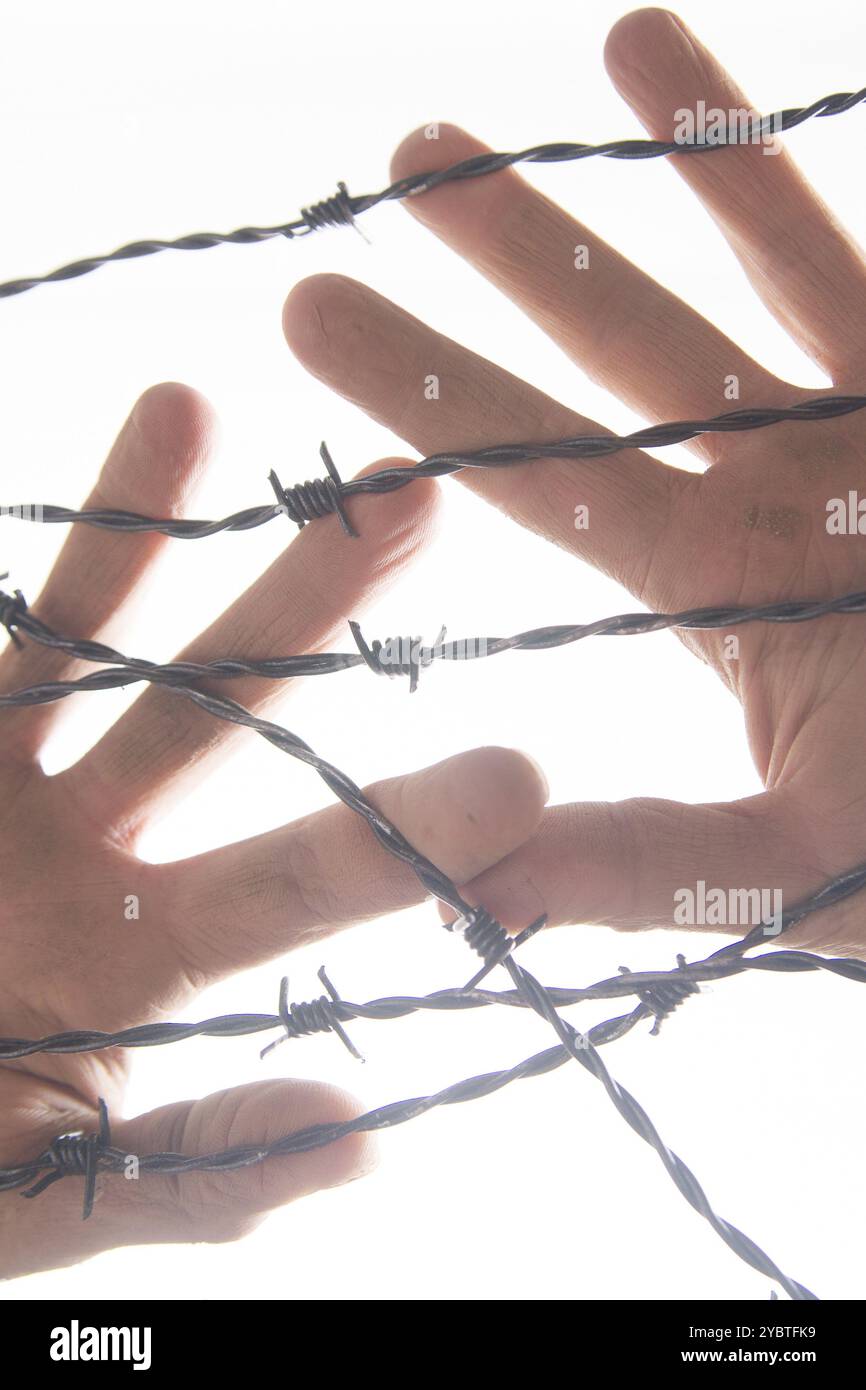Hands gripping the barbed wire in the sign to run away with the white ...