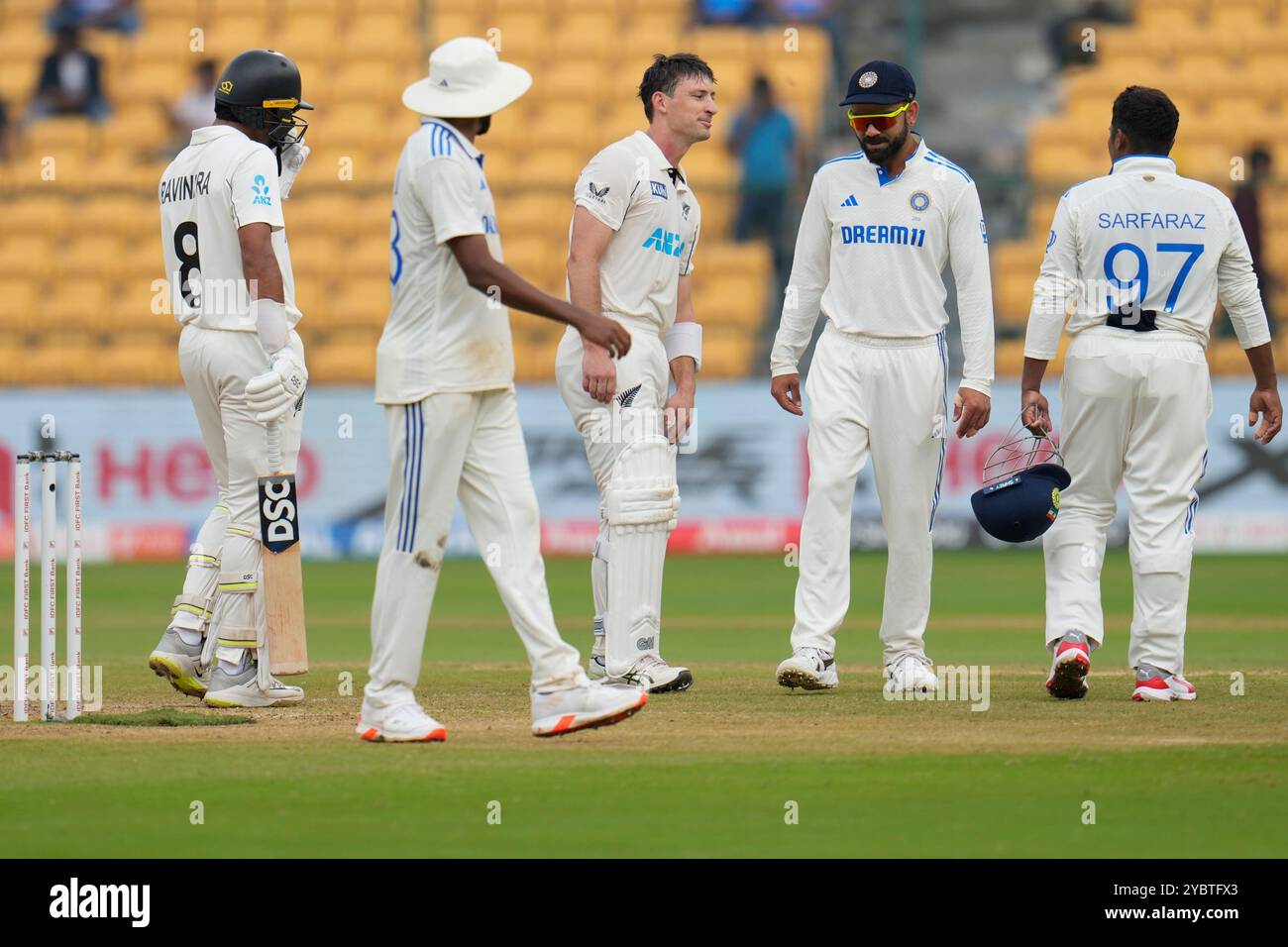 New Zealand's Will Young, center, interacts with Indian players after the ball hit on his helmet ...