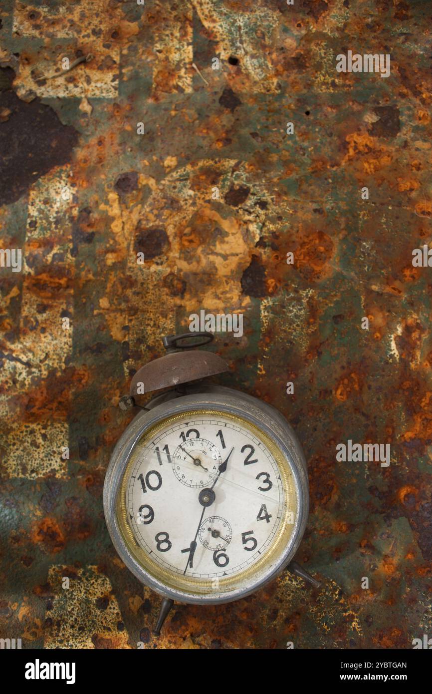 Old alarm clock resting on rusty metallic background Stock Photo - Alamy