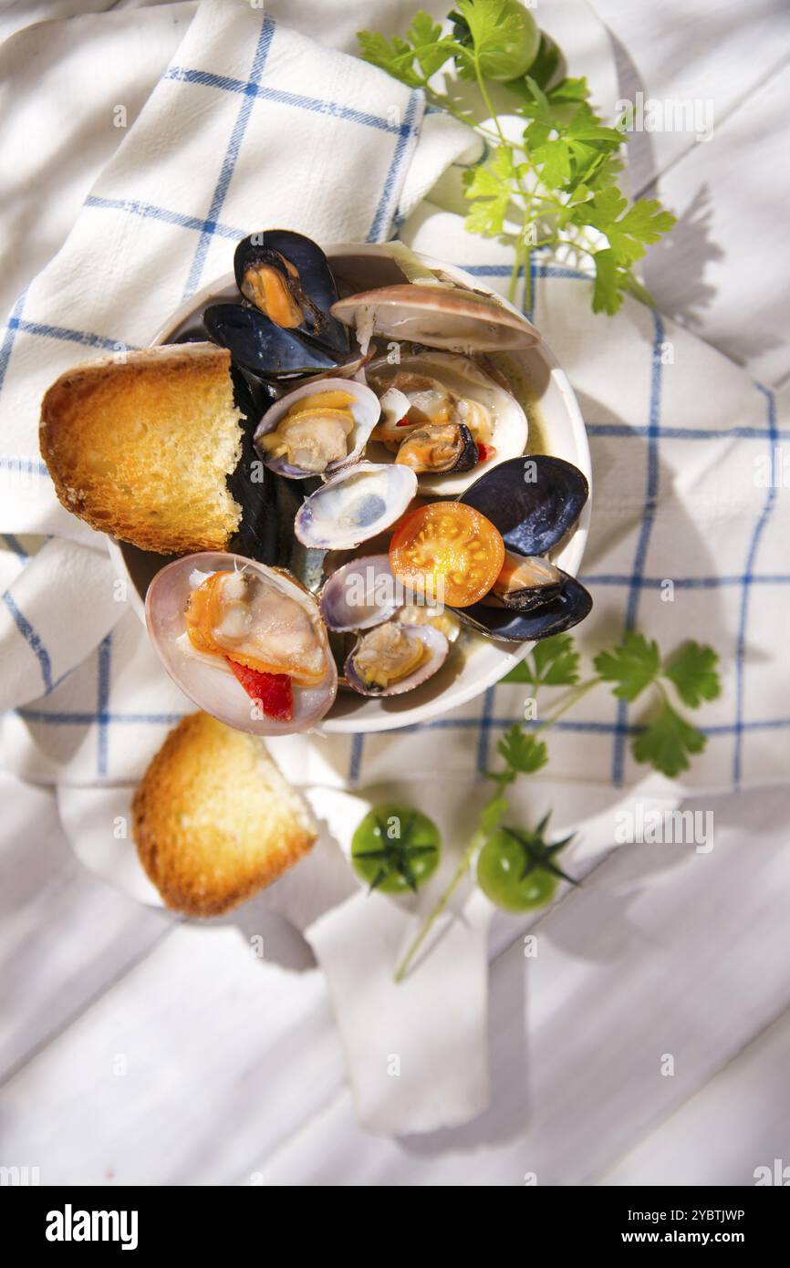 Presentation of a soup with seafood on white background Stock Photo - Alamy