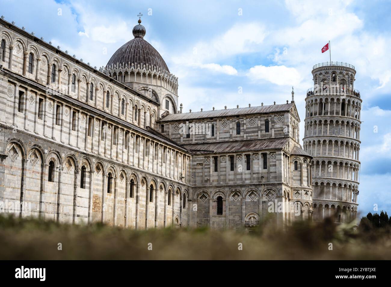Historic architecture with the Leaning Tower of Pisa under a blue sky ...
