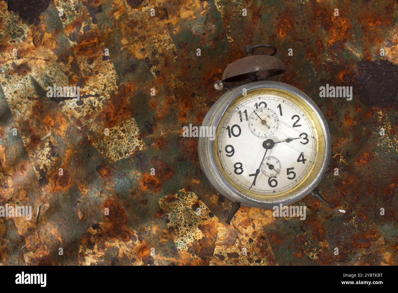 Old alarm clock resting on rusty metallic background Stock Photo - Alamy