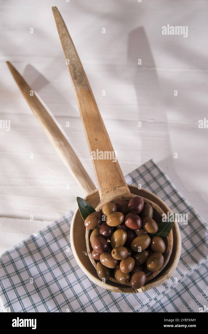 Presentation of a small group of black olives on wooden ladle Stock ...