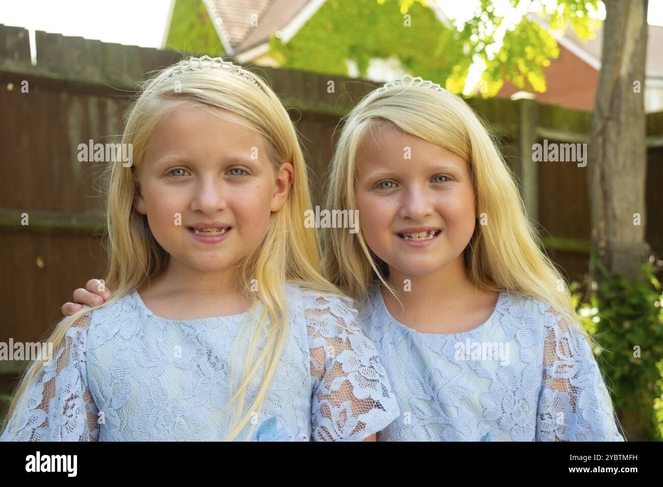Portrait of pre teen twin caucasian girls looking at the camera themes ...