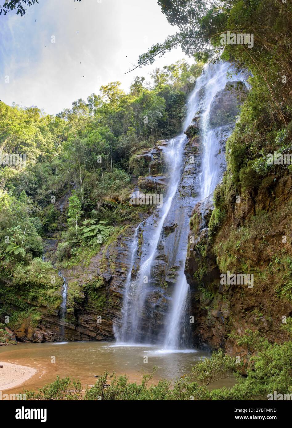 Stunning waterfall among the dense vegetation and rocks of the ...
