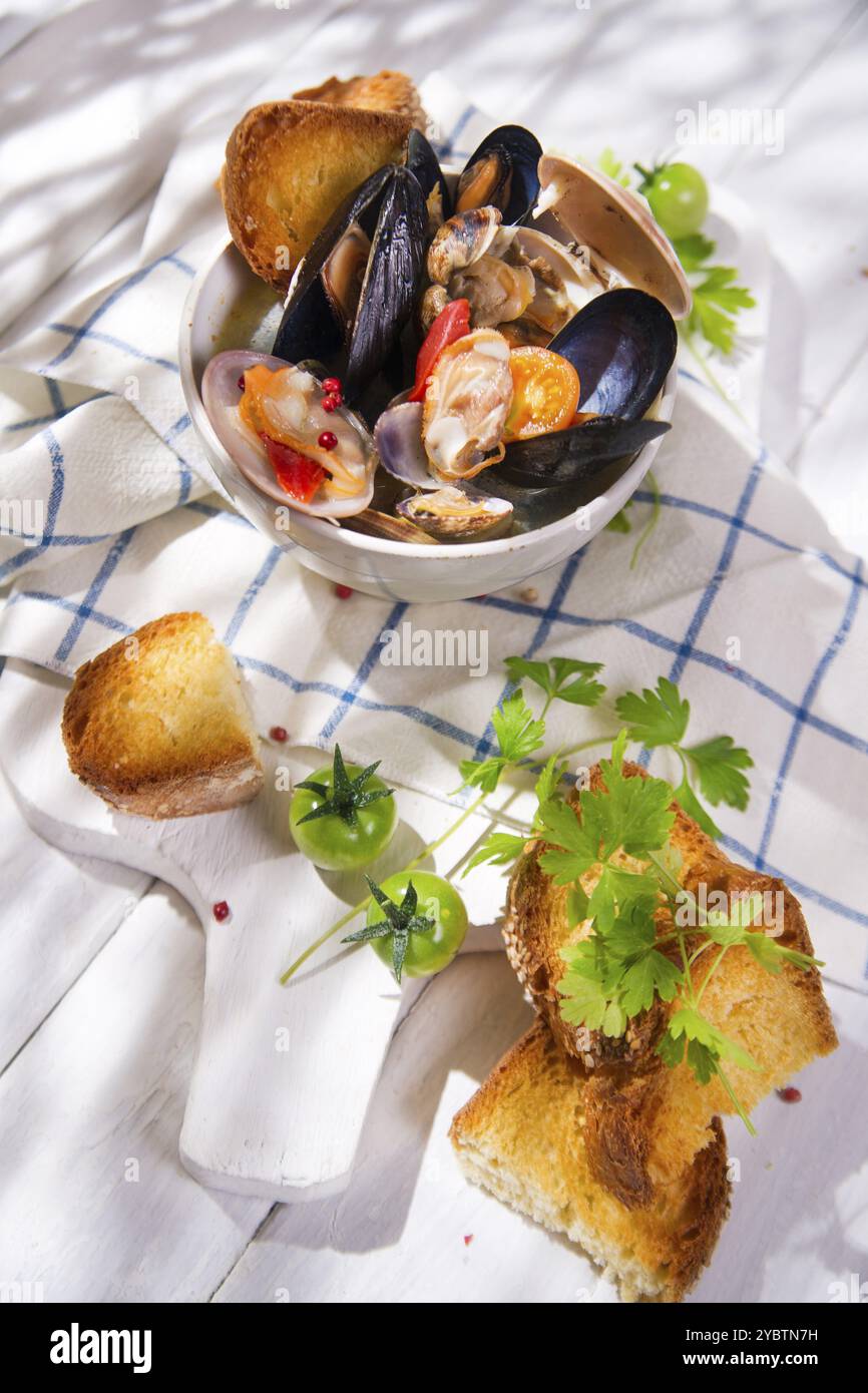 Presentation of a soup with seafood on white background Stock Photo - Alamy