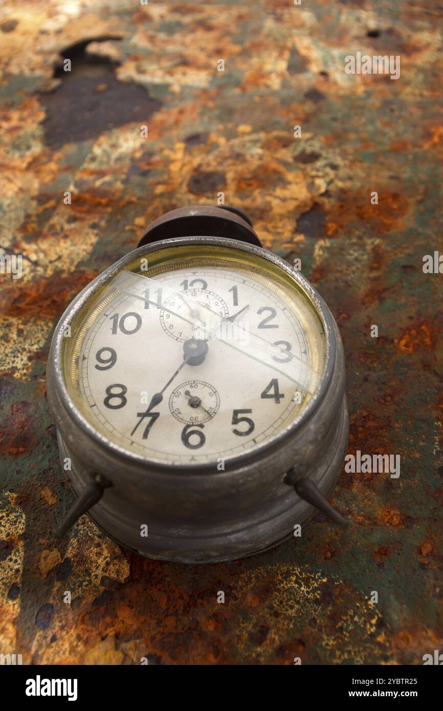 Old alarm clock resting on rusty metallic background Stock Photo - Alamy
