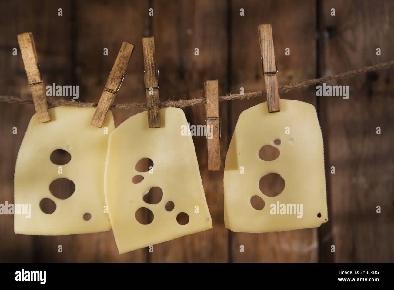 Presentation of slices of Swiss cheese Emmentaler hanging by a thread ...