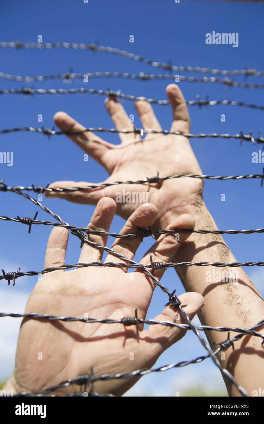 Hands gripping the barbed wire in the sign to run away with the blue ...
