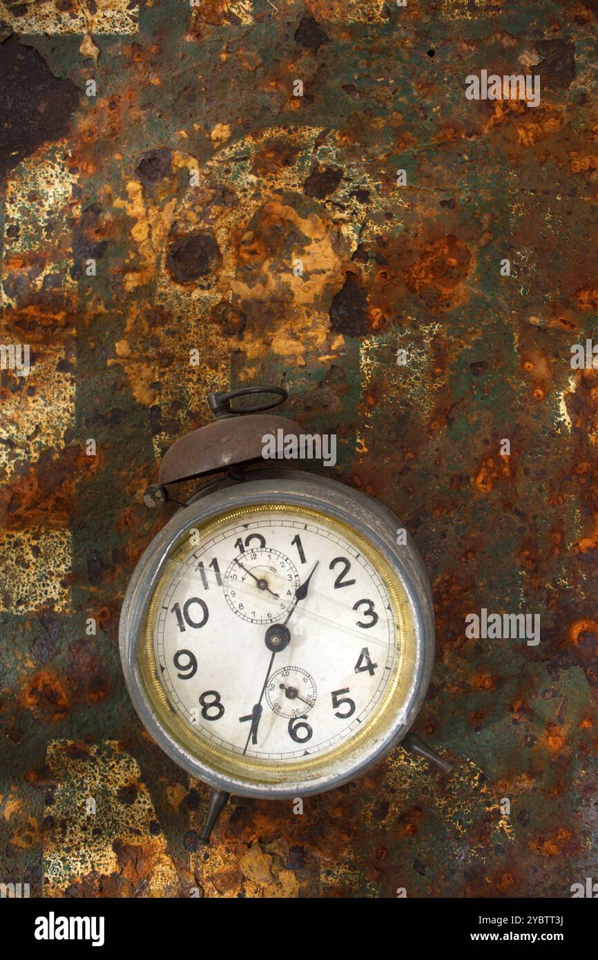 Old alarm clock resting on rusty metallic background Stock Photo - Alamy