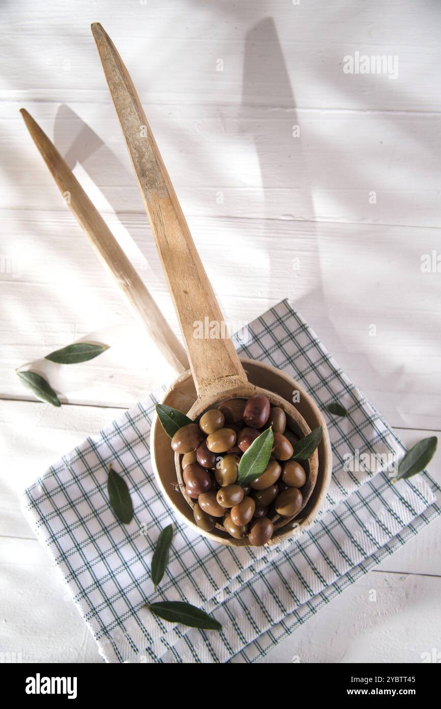 Presentation of a small group of black olives on wooden ladle Stock ...