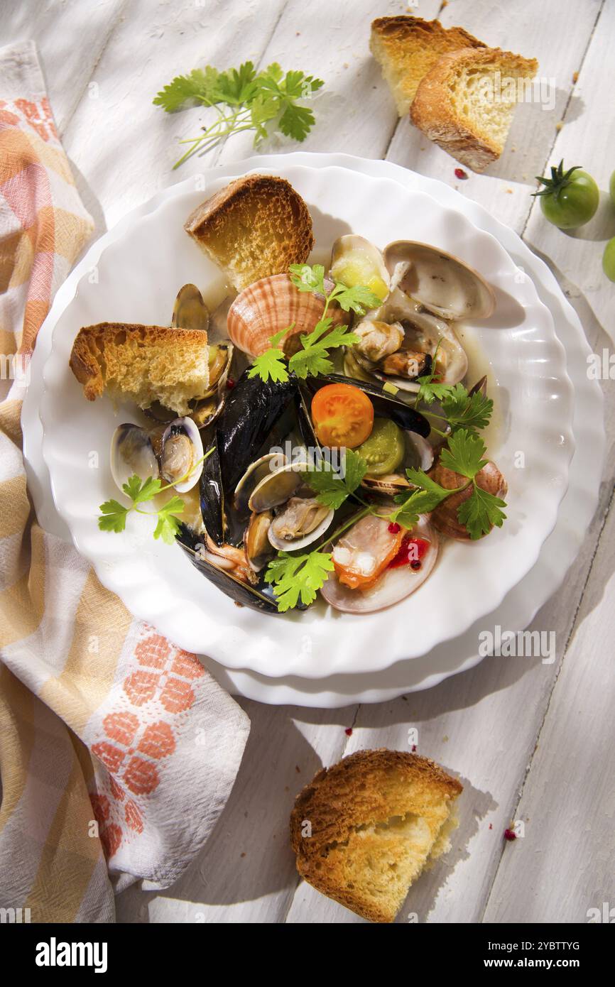 Presentation of a soup with seafood with roasted bread Stock Photo - Alamy