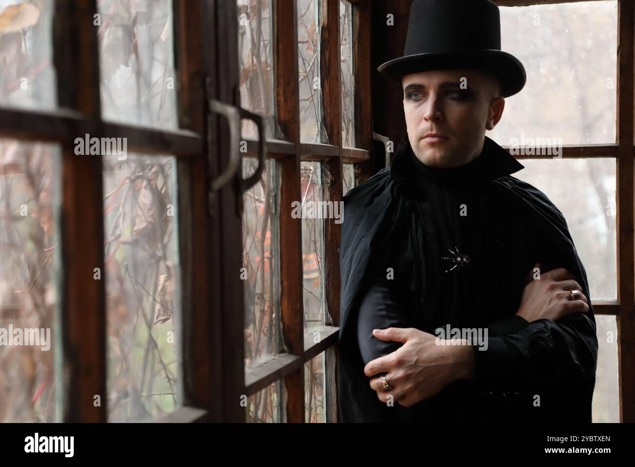 Portrait of a young handsome Lord of vampires at the window of the old ...