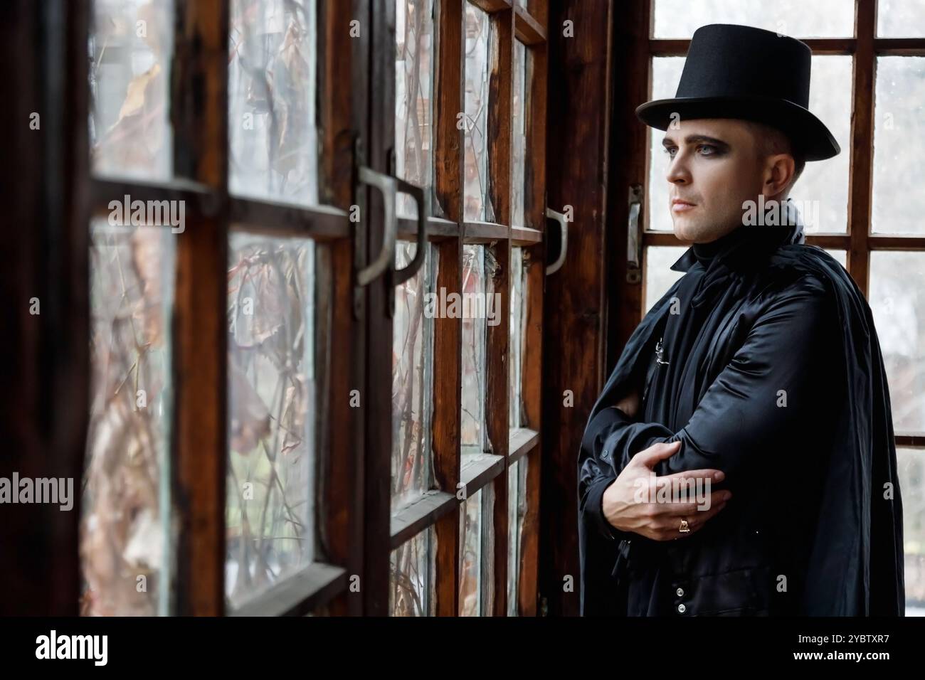 Portrait of a handsome young adult man in old fashioned vampire style ...