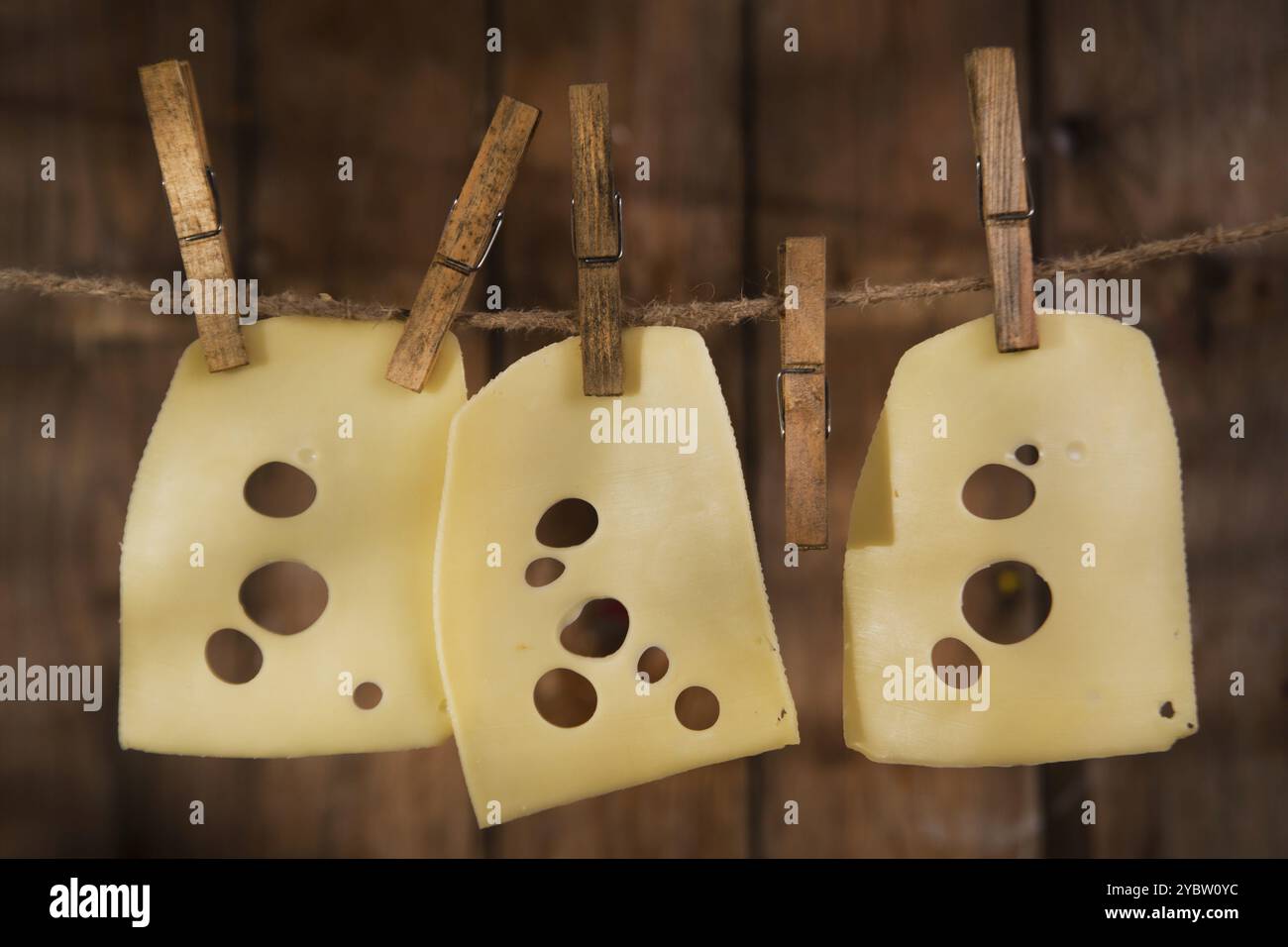 Presentation of slices of Swiss cheese Emmentaler hanging by a thread ...