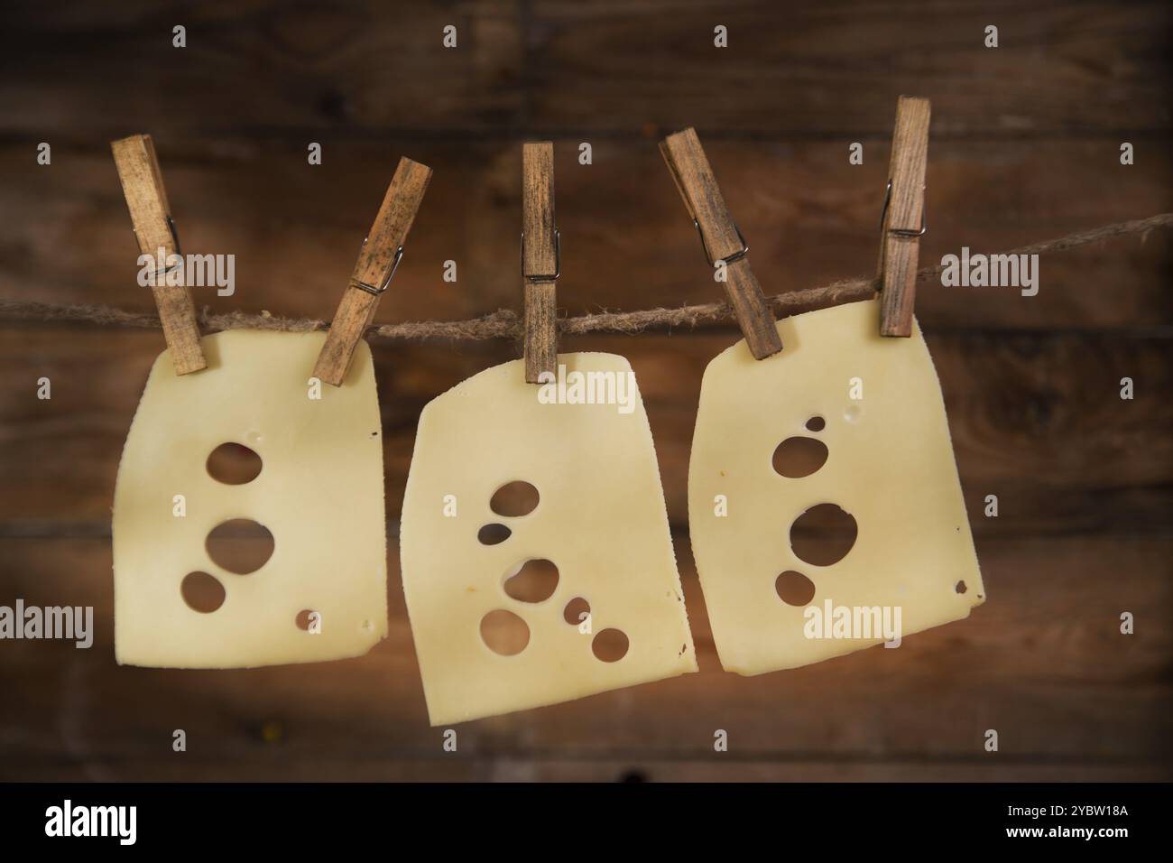 Presentation of slices of Swiss cheese Emmentaler hanging by a thread ...