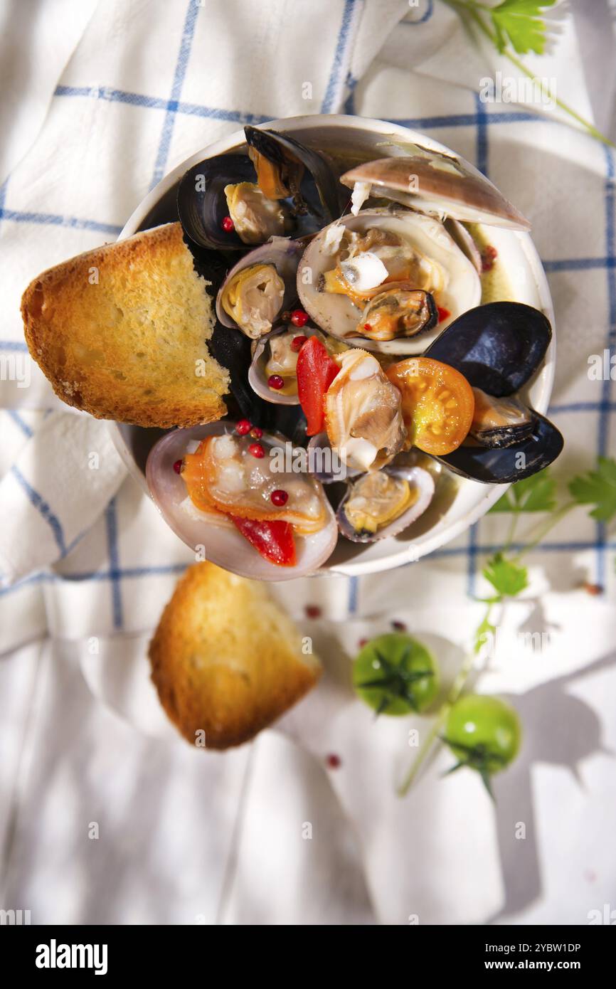 Presentation of a soup with seafood on white background Stock Photo - Alamy