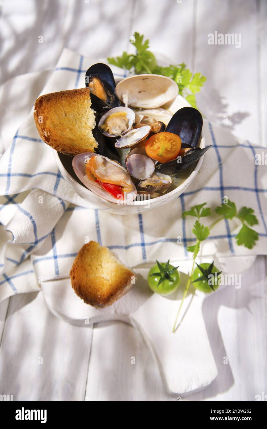 Presentation of a soup with seafood on white background Stock Photo - Alamy