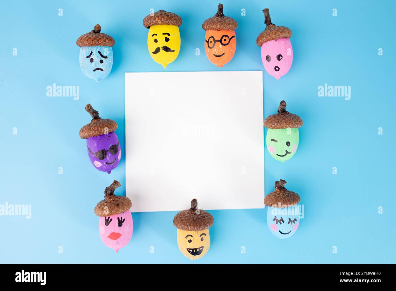 Painted emoji acorns, unpainted acorns, brushes, and palette on blue ...
