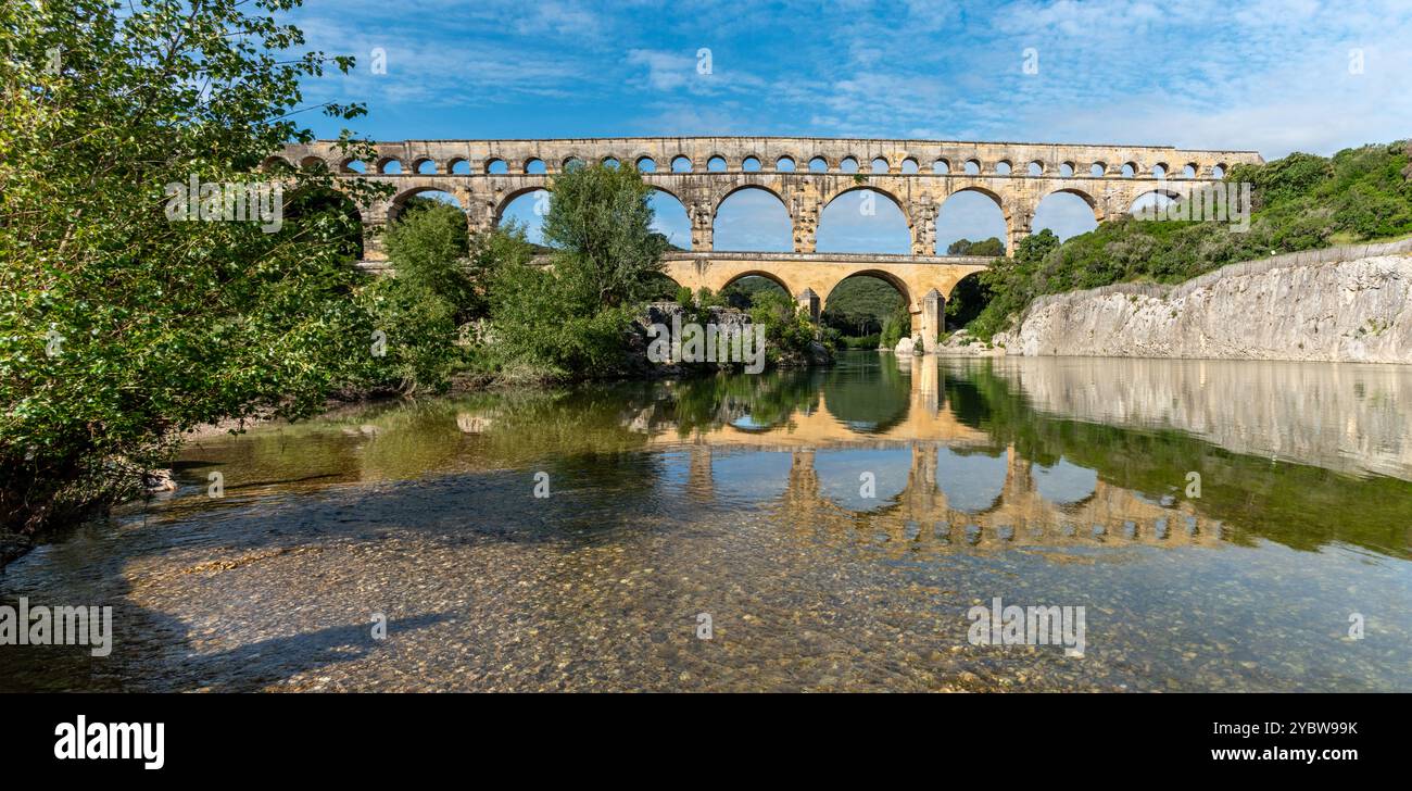 Famous Roman aqueduct Pont du Gard mirroring in the river, France Stock ...