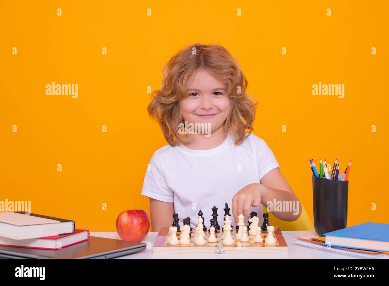 Kid play chess on isolated studio background. Child think about chess ...
