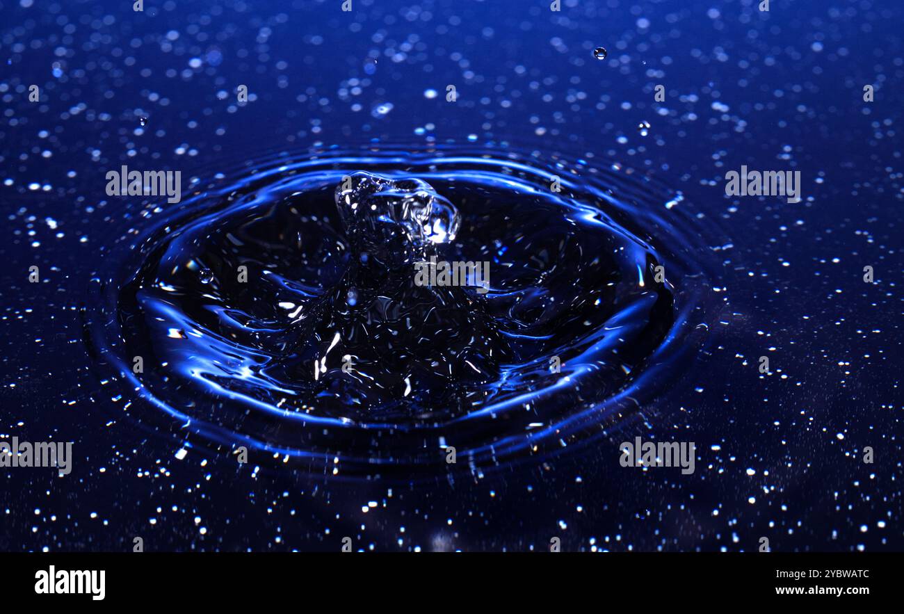 Splash - a drop falling onto the water surface in color in a macro shot ...