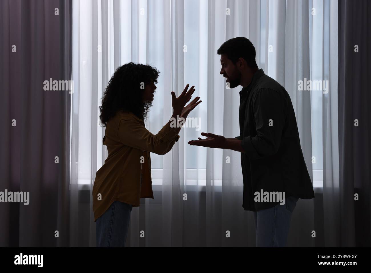 Emotional couple arguing indoors at night. Relationship problems Stock ...