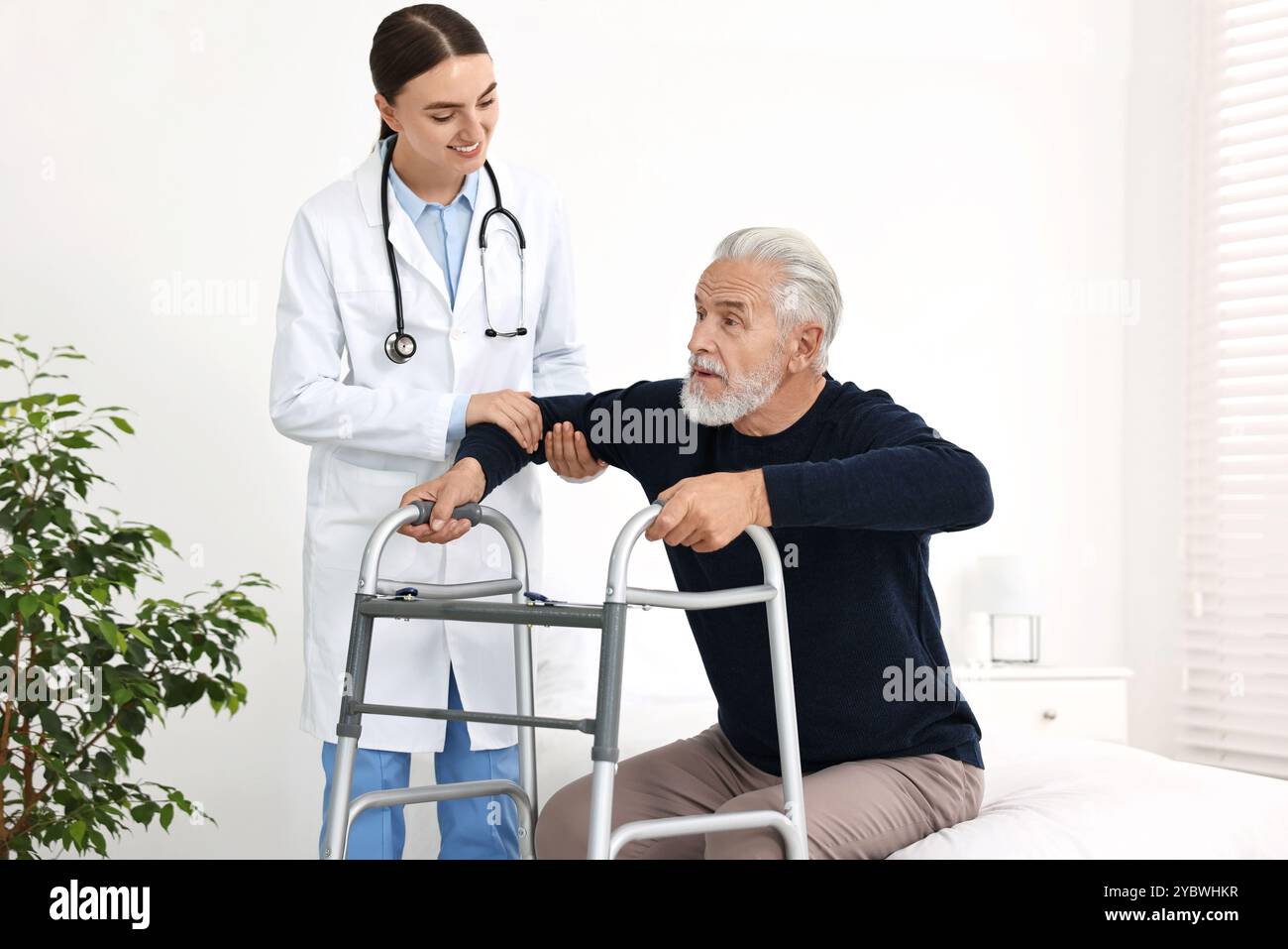 Doctor helping young man rehabilitation hi-res stock photography and ...