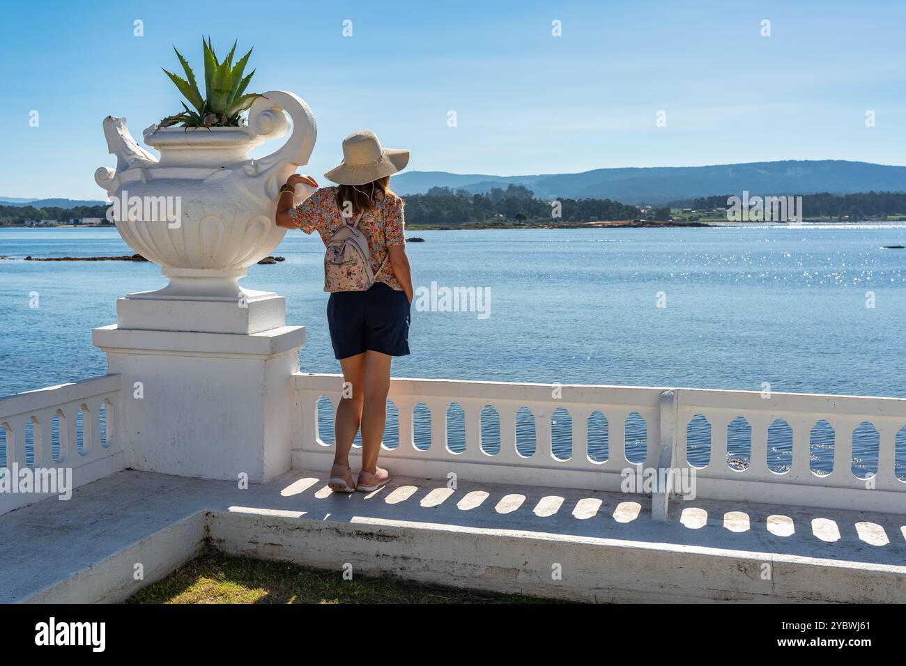 Tourist woman enjoying the sea views on the promenade of the island of ...
