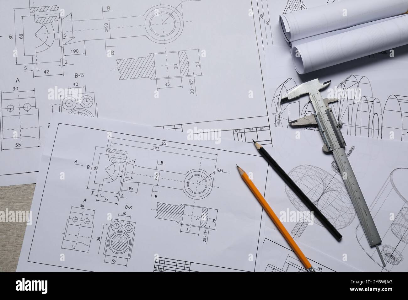 Different engineering drawings, vernier caliper and pencils on table ...