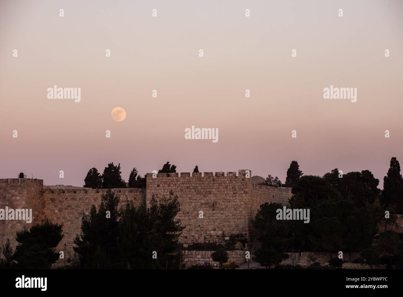 Full moon rise over a section of the ancient walls and ramparts of the ...