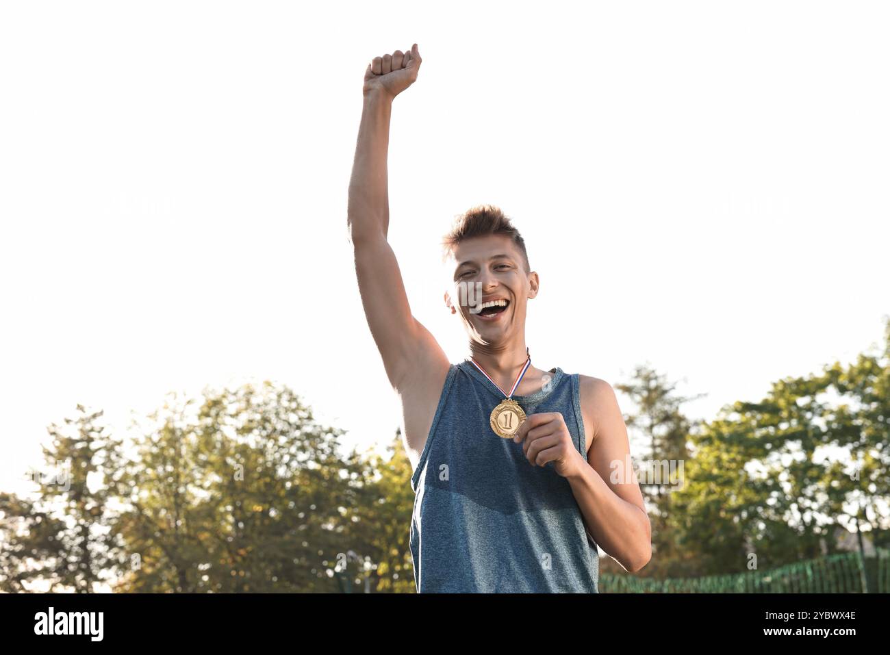 Happy young winner with golden medal outdoors Stock Photo - Alamy