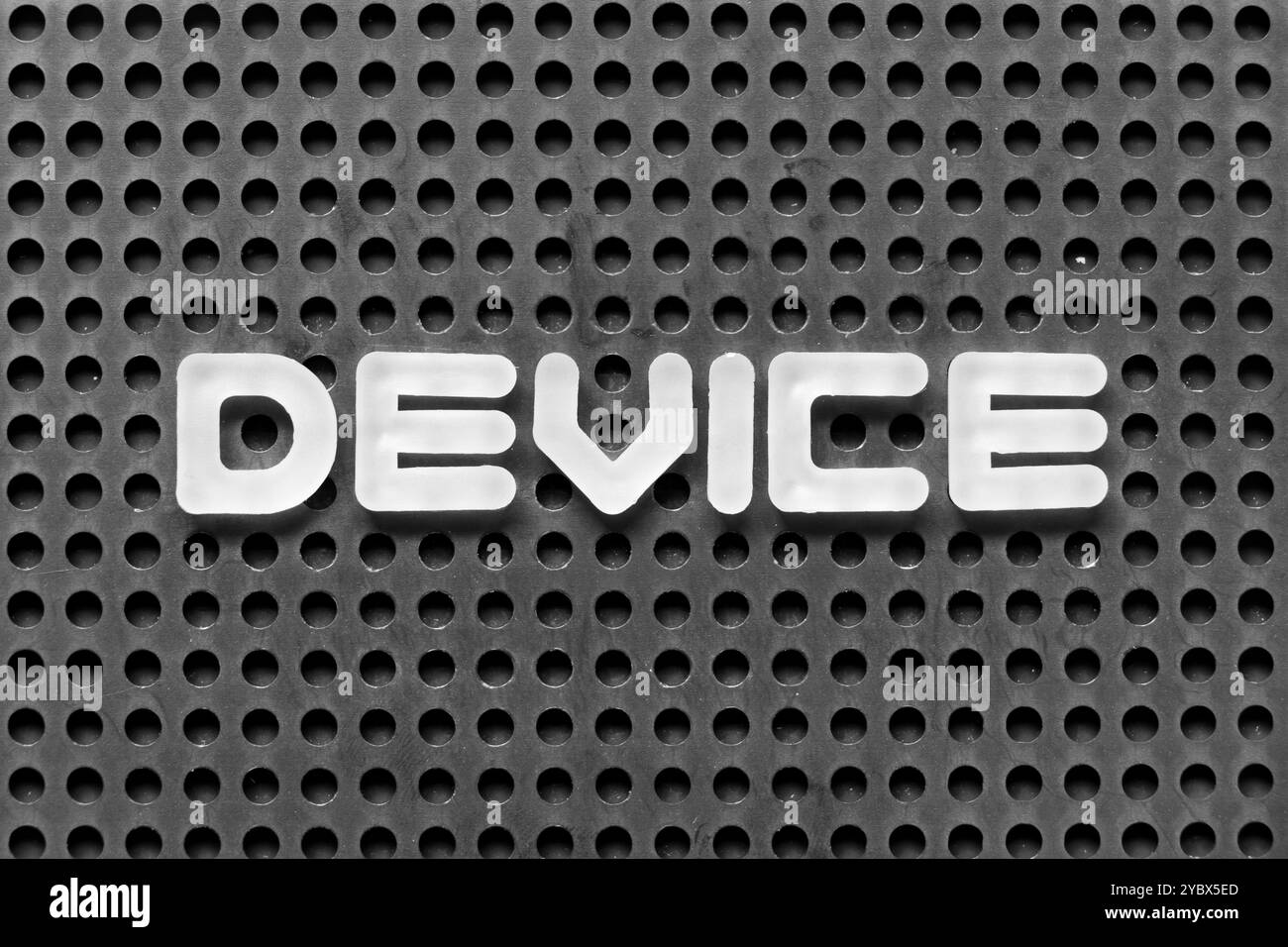 White alphabet letter in word device on black pegboard background Stock ...