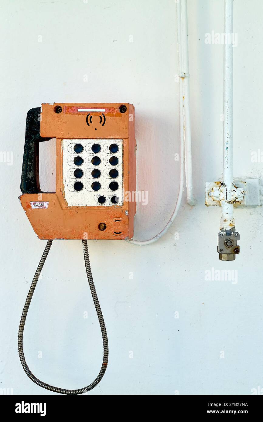 This image captures a nostalgic maritime phone fixed to a ship s white ...