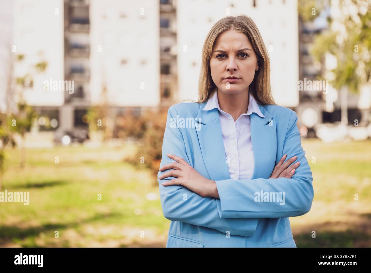 Portrait of angry businesswoman with arms crossed standing outdoor ...