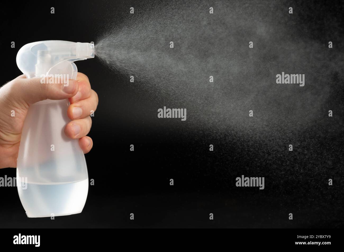 Liquid sprayer in hand side view on black studio background isolated ...