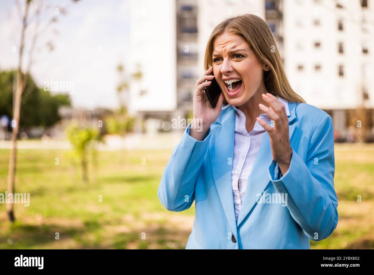 Image of angry businesswoman screaming on the phone while standing ...