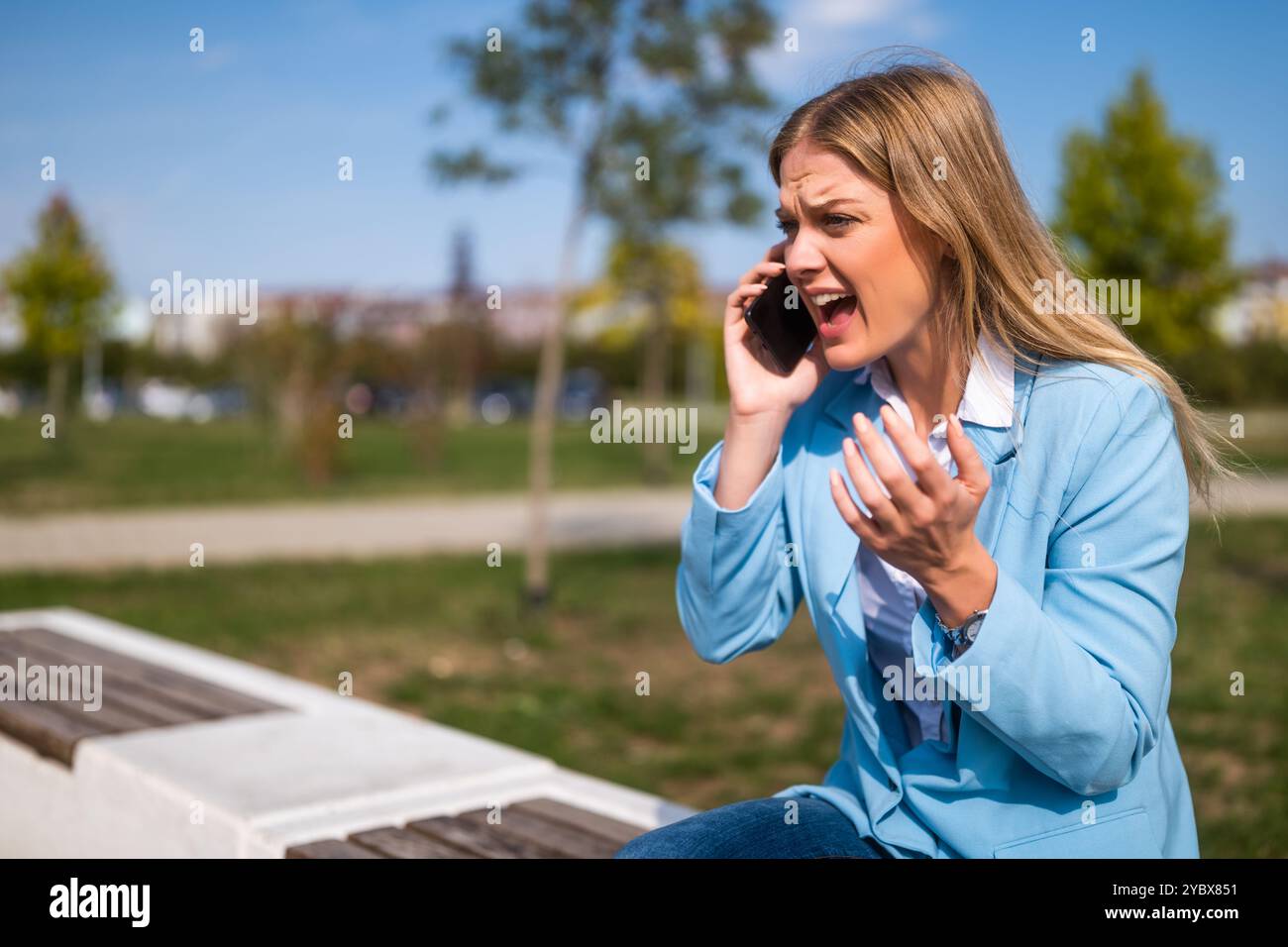 Image of angry businesswoman screaming on the phone while sitting on ...
