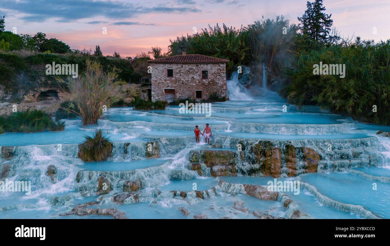 a couple of man and woman enjoy the soothing warm waters of Saturnia ...