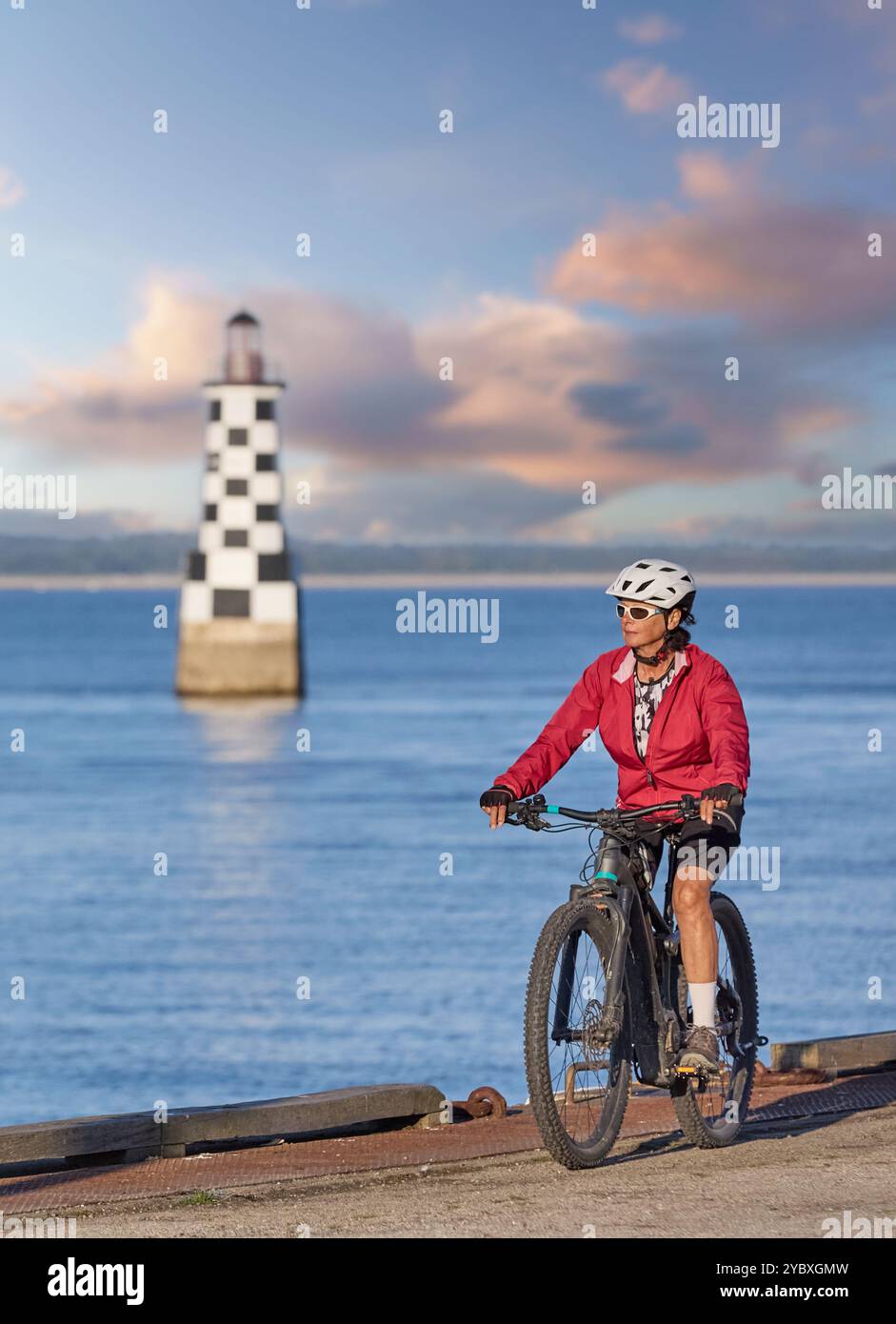 active senior woman cycling with her electric mountain bike along the ...