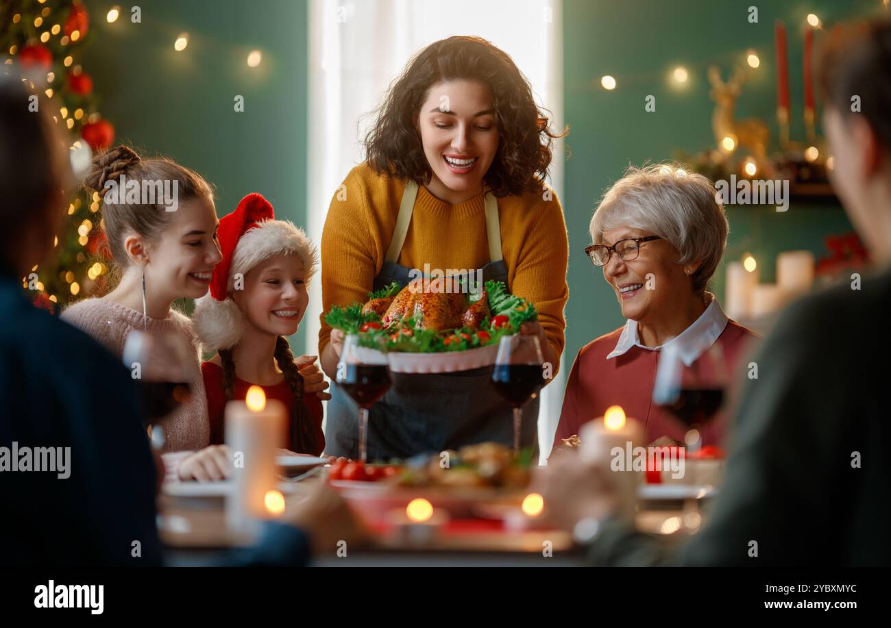 Merry Christmas. Happy family are having dinner at home. Celebration holiday and togetherness ...