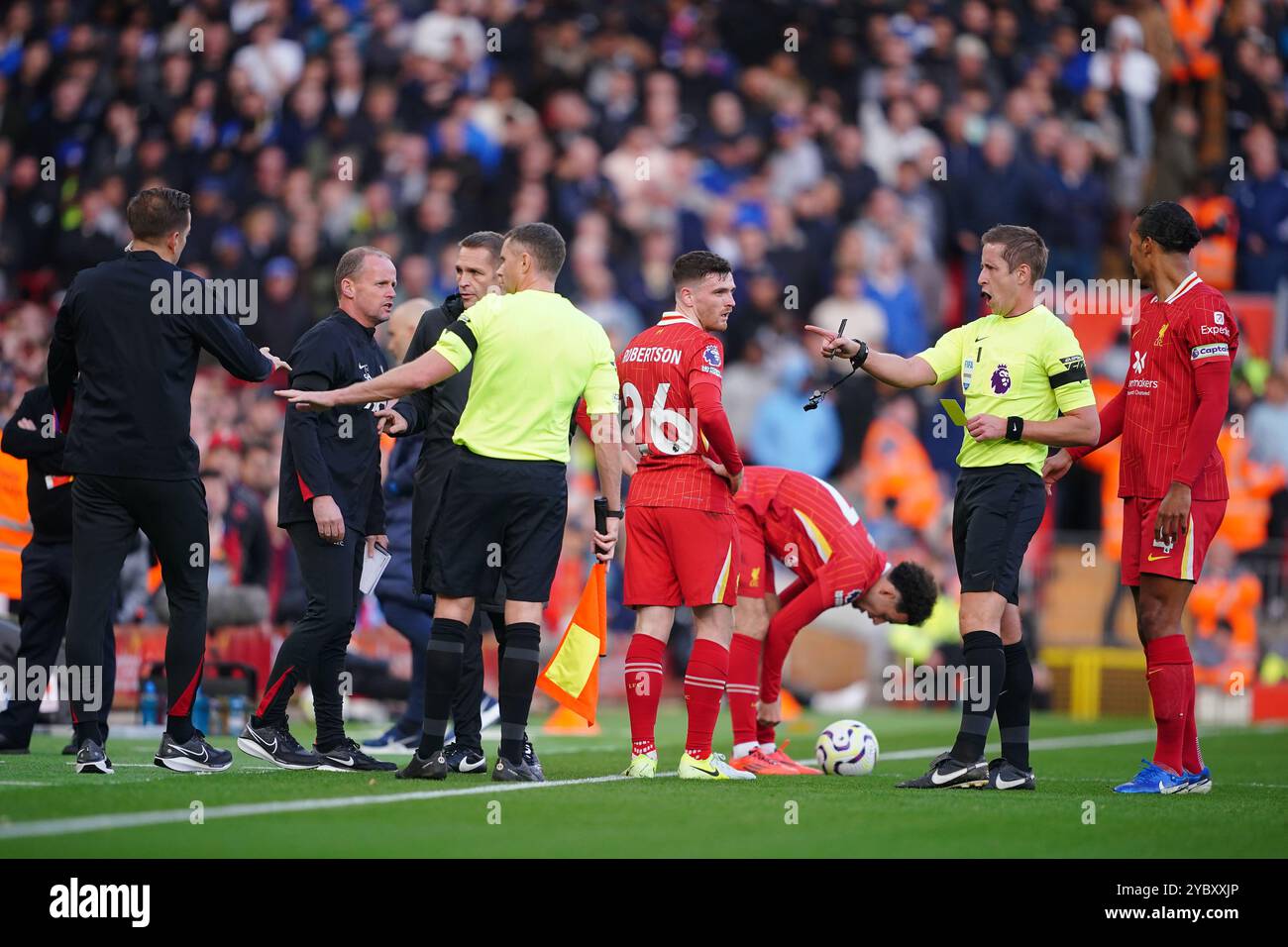 Referee John Brooks (second from right) shows Liverpool manager Arne ...